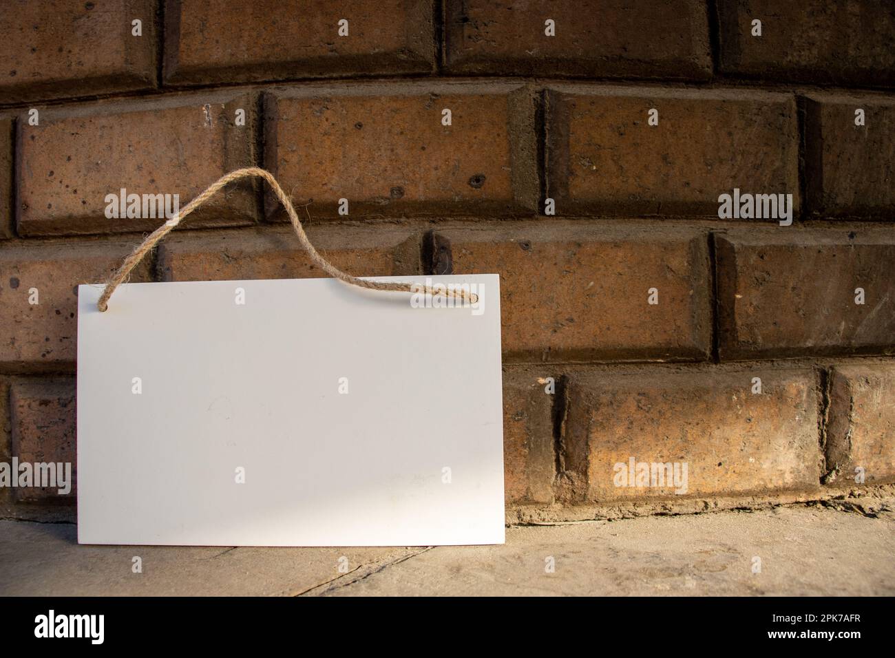 brick background white hanging picture sign with empty free space for ...