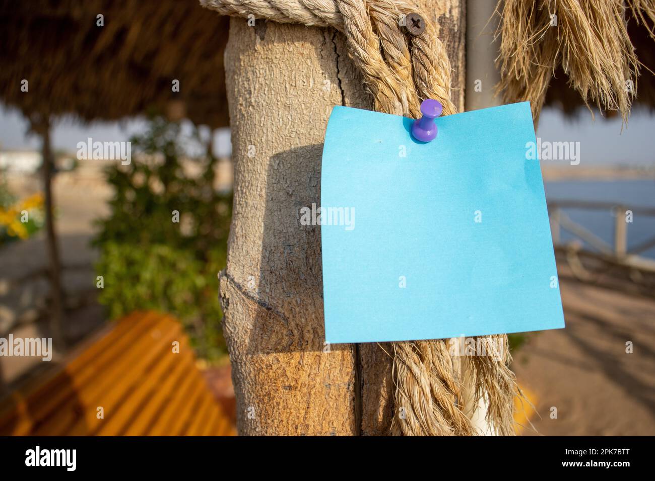 rope with wooden post and a blue square paper note with empty free ...