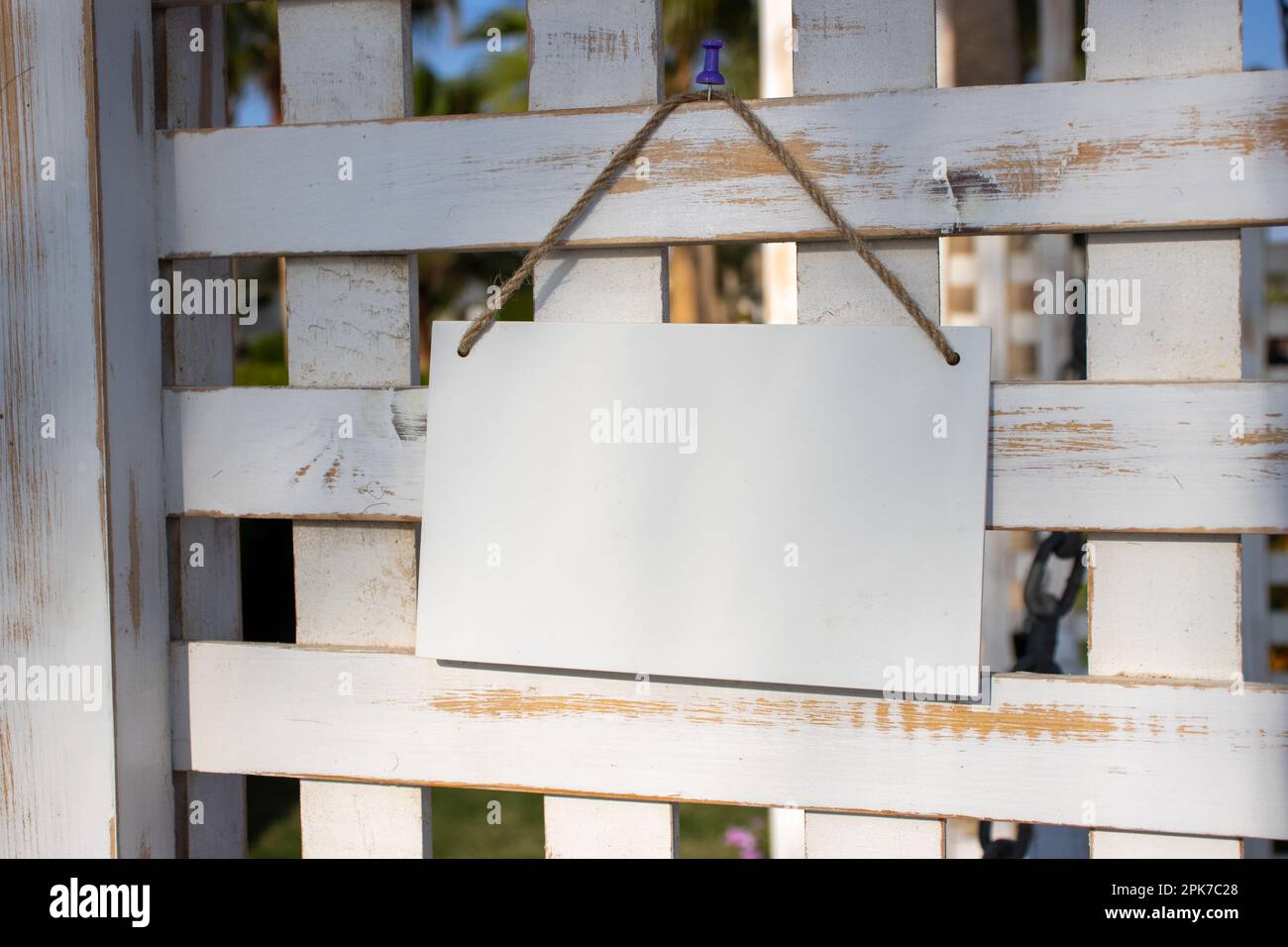 rustic wooden white lattice work with a white hanging picture sign with ...