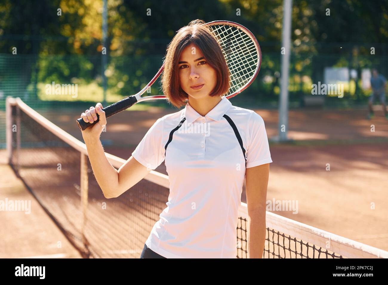 Standing with racket in hand. Female tennis player is on the court at ...