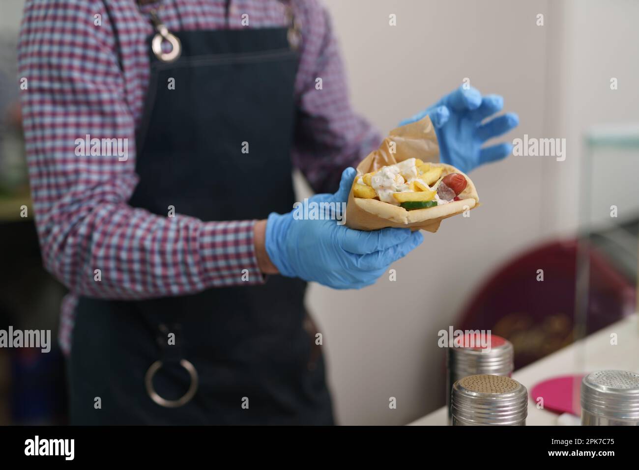 Cook preparing gyros wrap sandwich in a fast food restaurant. Male ...