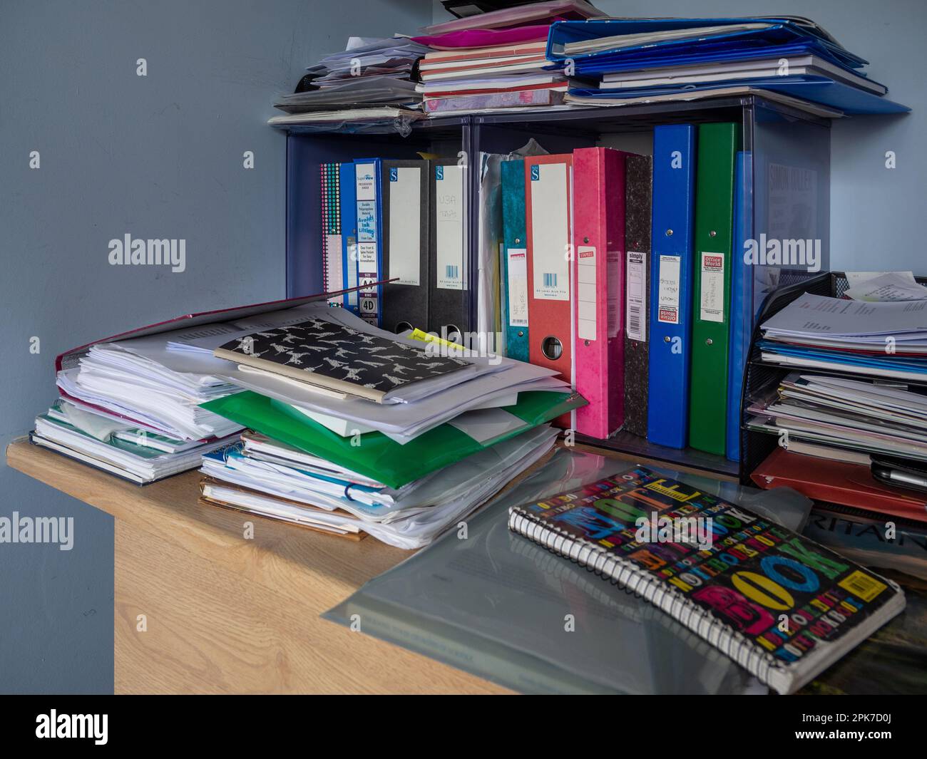 Cluttered, untidy corner of a home office, UK; stacks of files, papers ...