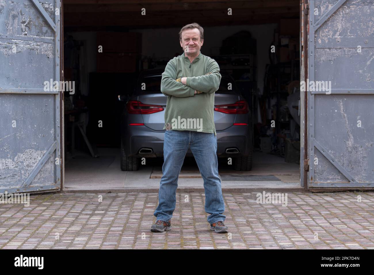 Smiling mechanic stands crossed arms hi-res stock photography and ...