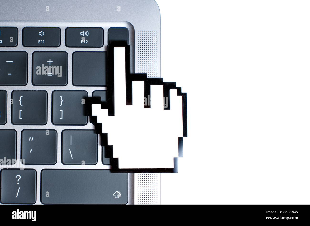 Large plastic pixelated hand cursor model touches a modern laptop's ...
