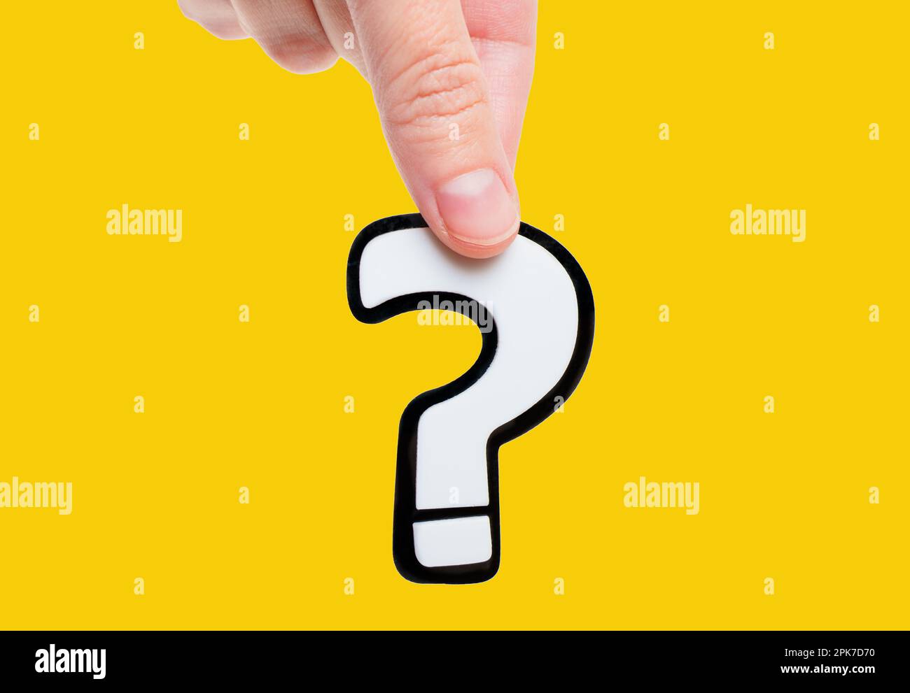 Close-up of a female hand holding a large white question mark symbol ...