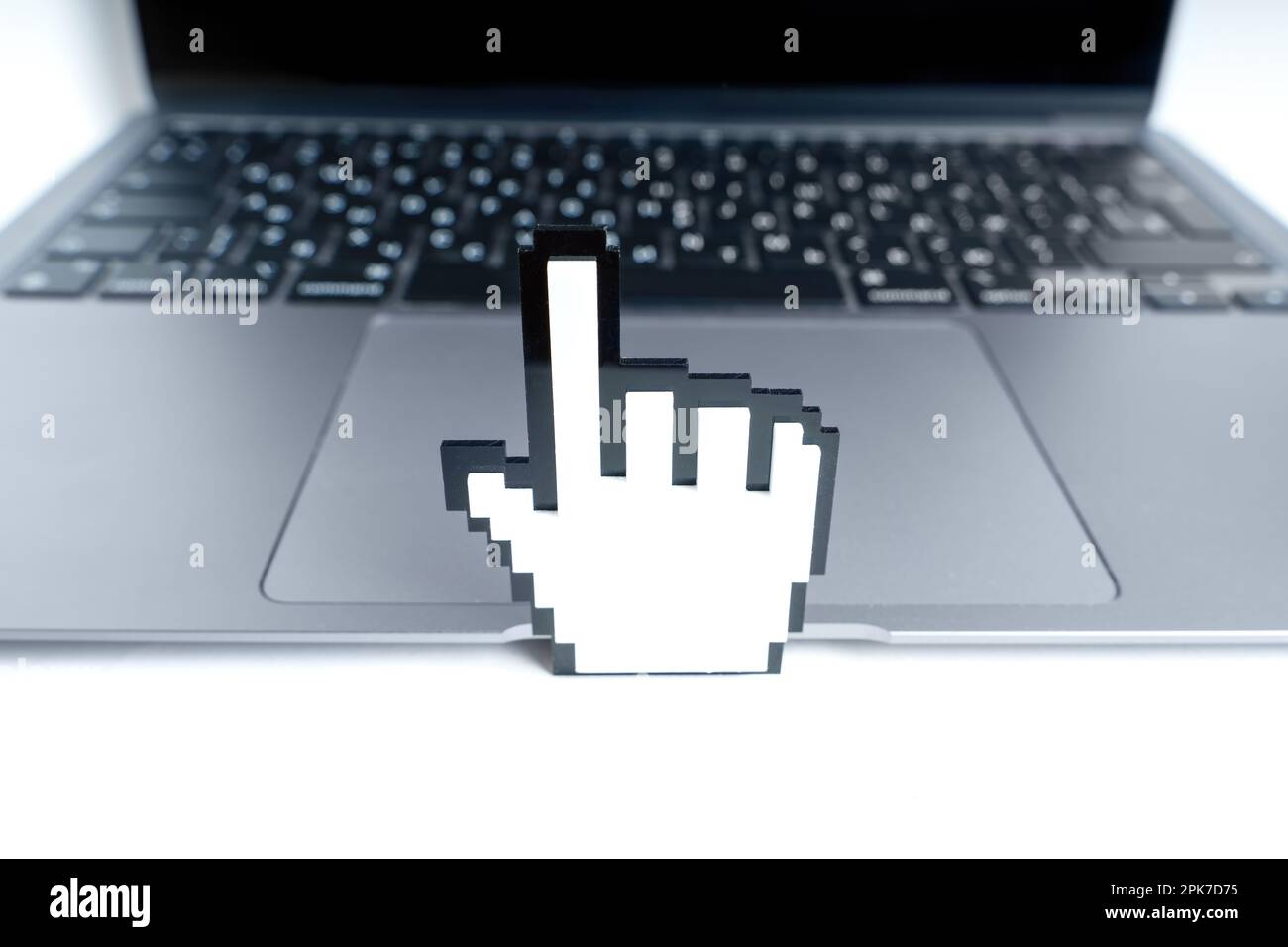 Large pixelated hand-shaped cursor placed in front of a modern laptop ...