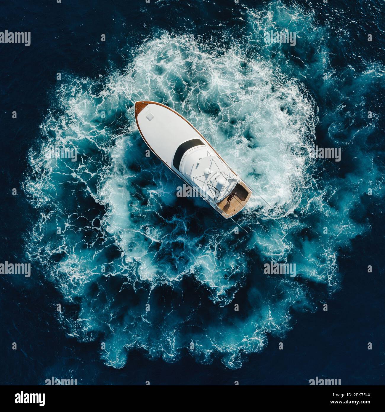 Beautiful top-down view of a boat spinning in the ocean in blue water ...