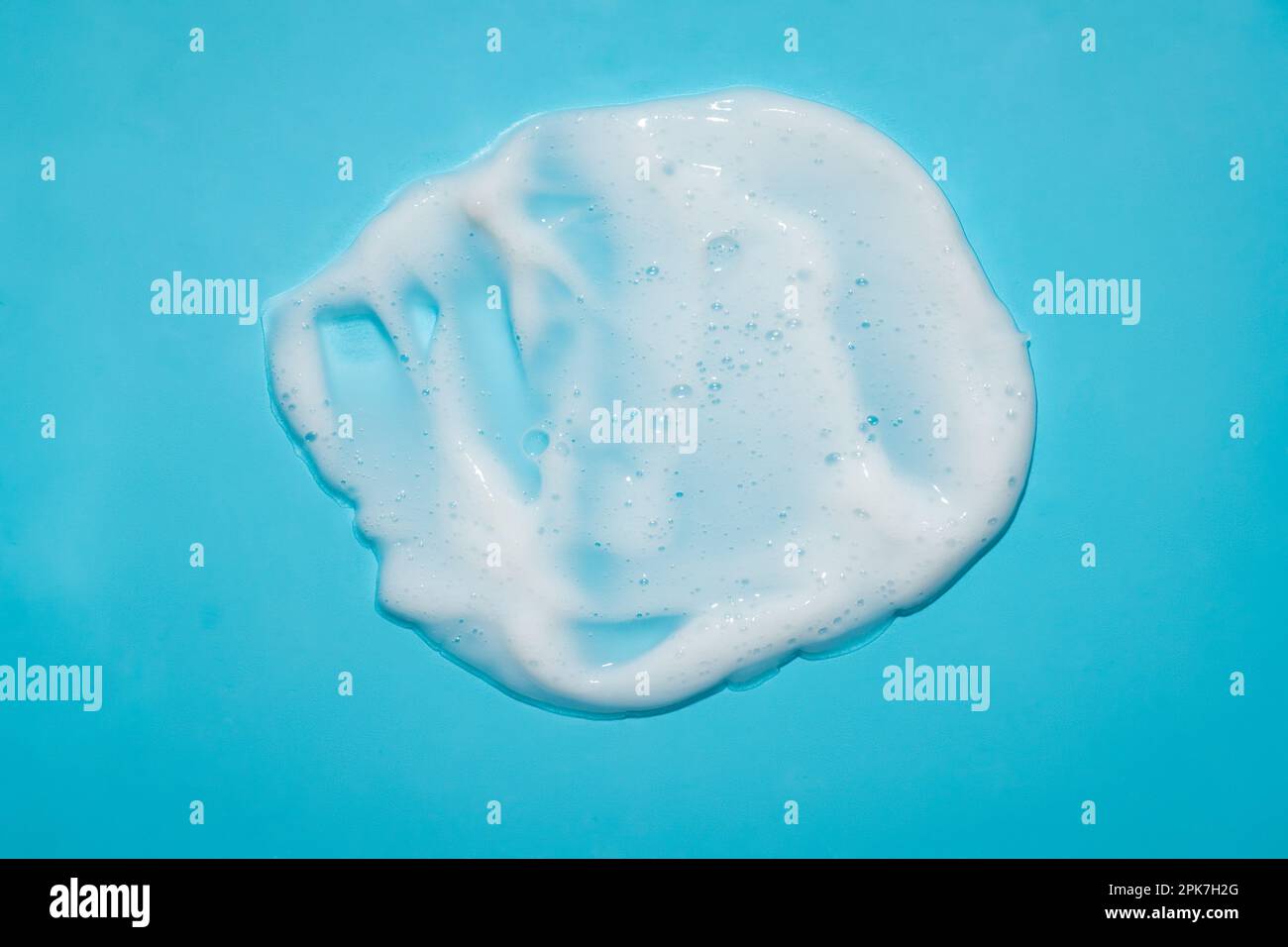 White lather foam moisturizer cream lotion cleanser on blue background ...