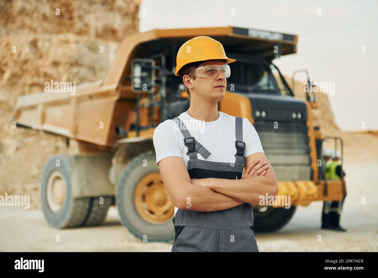 Professional loading vehicle. Worker in uniform is on the borrow pit at daytime Stock Photo - Alamy