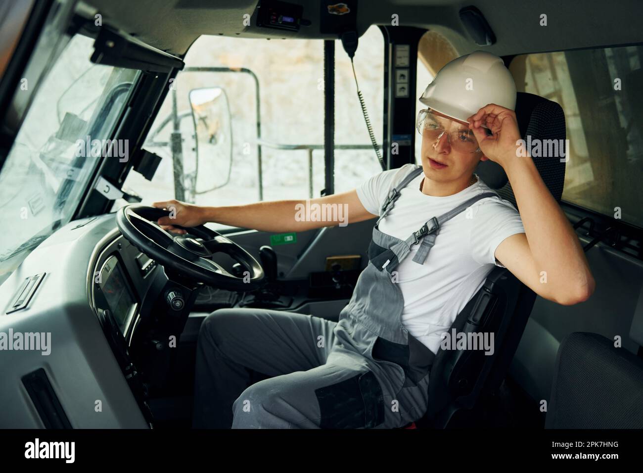 Driving transport. Worker in professional uniform is on the borrow pit at daytime Stock Photo ...