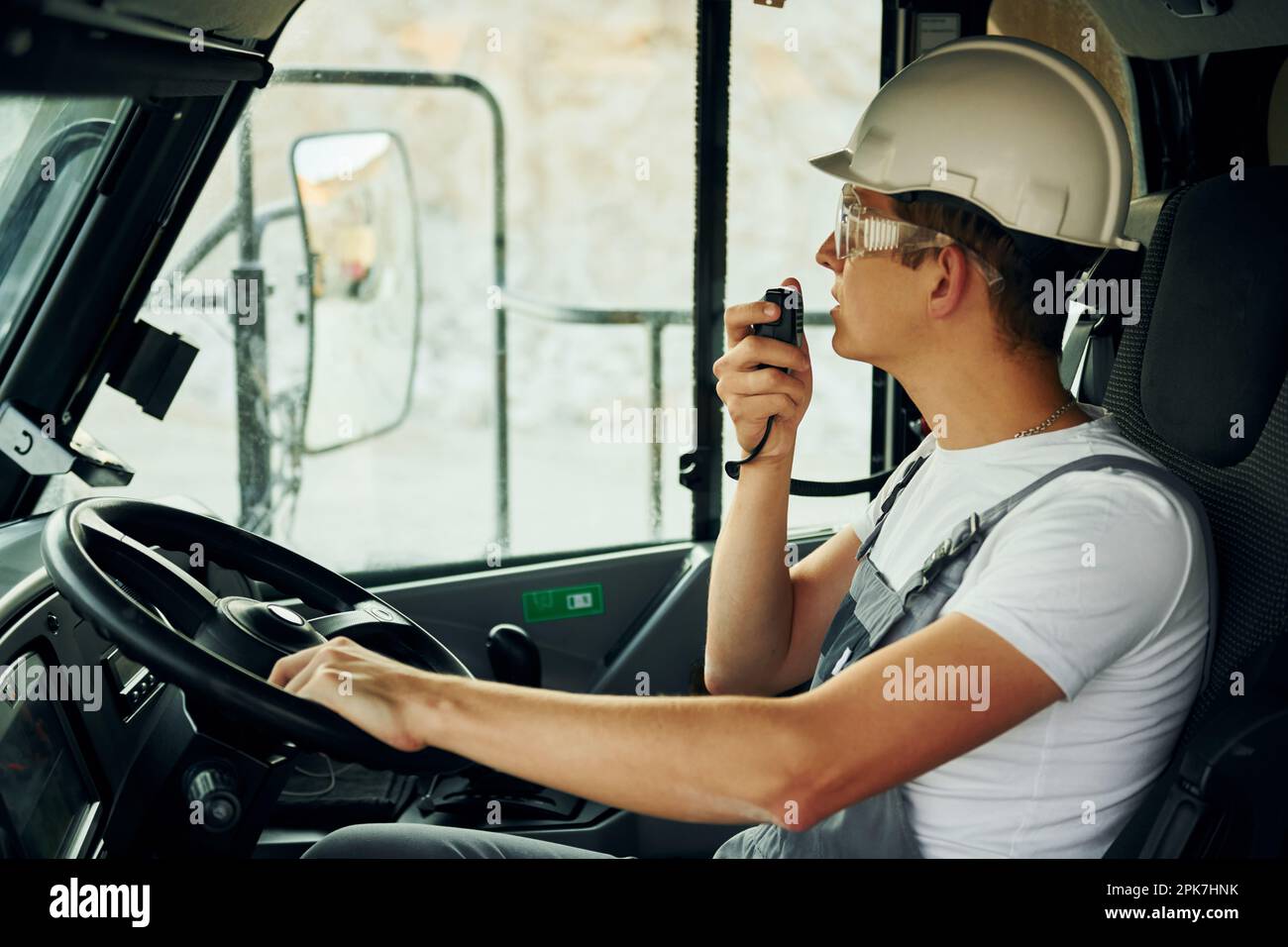 Driving transport. Worker in professional uniform is on the borrow pit ...