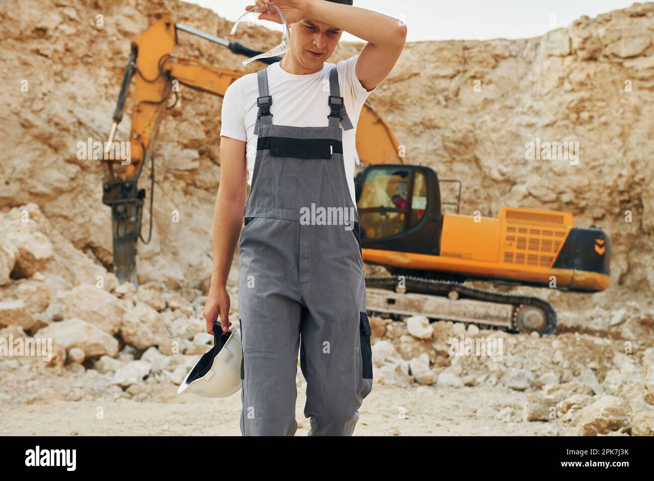 Operator is working on the borrow pit. Man in professional uniform ...