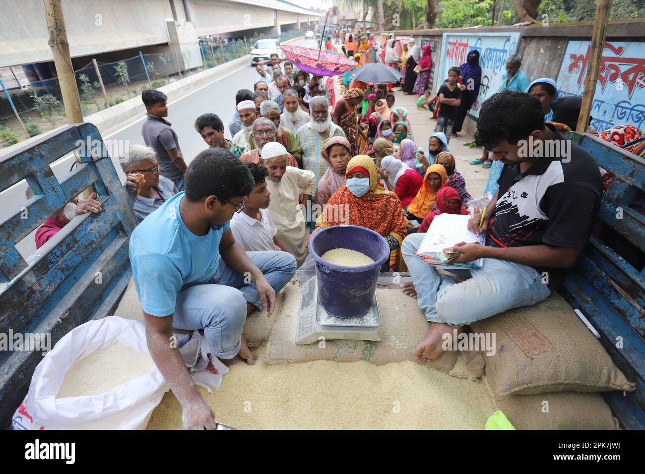 People from low-income groups wait in queues in front of the food ...