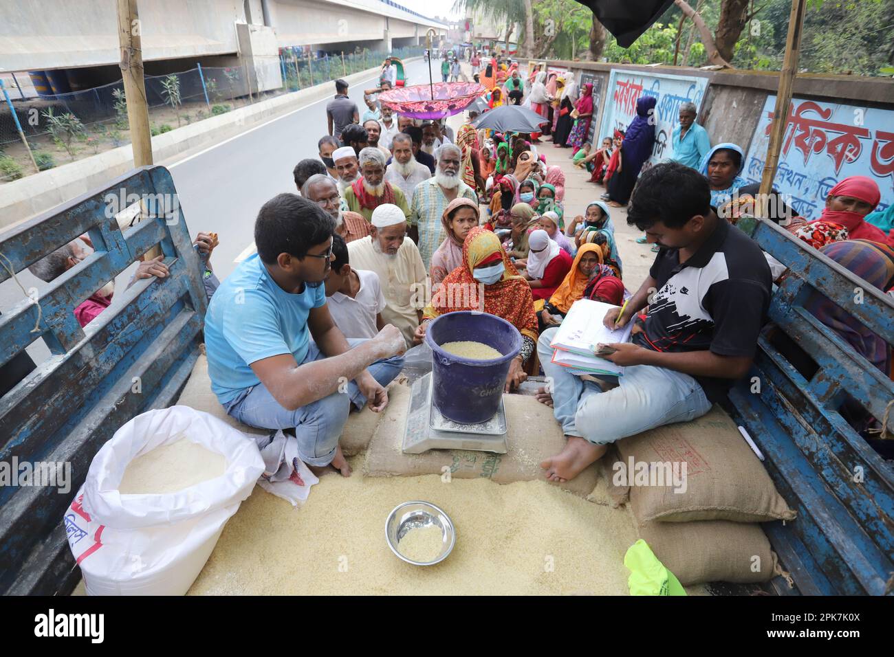 People from low-income groups wait in queues in front of the food ...
