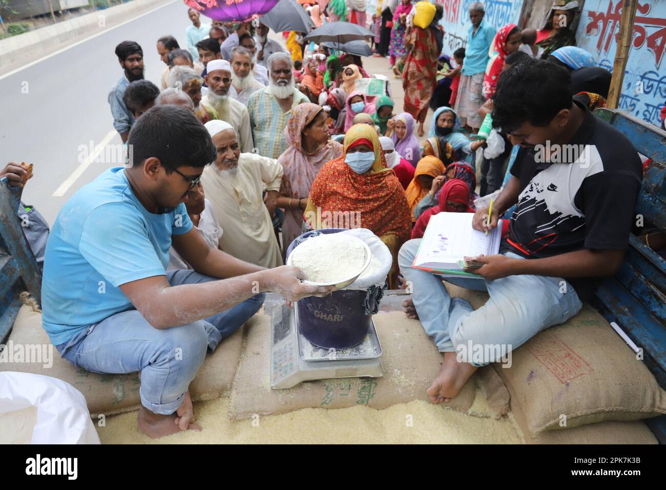 People from low-income groups wait in queues in front of the food ...