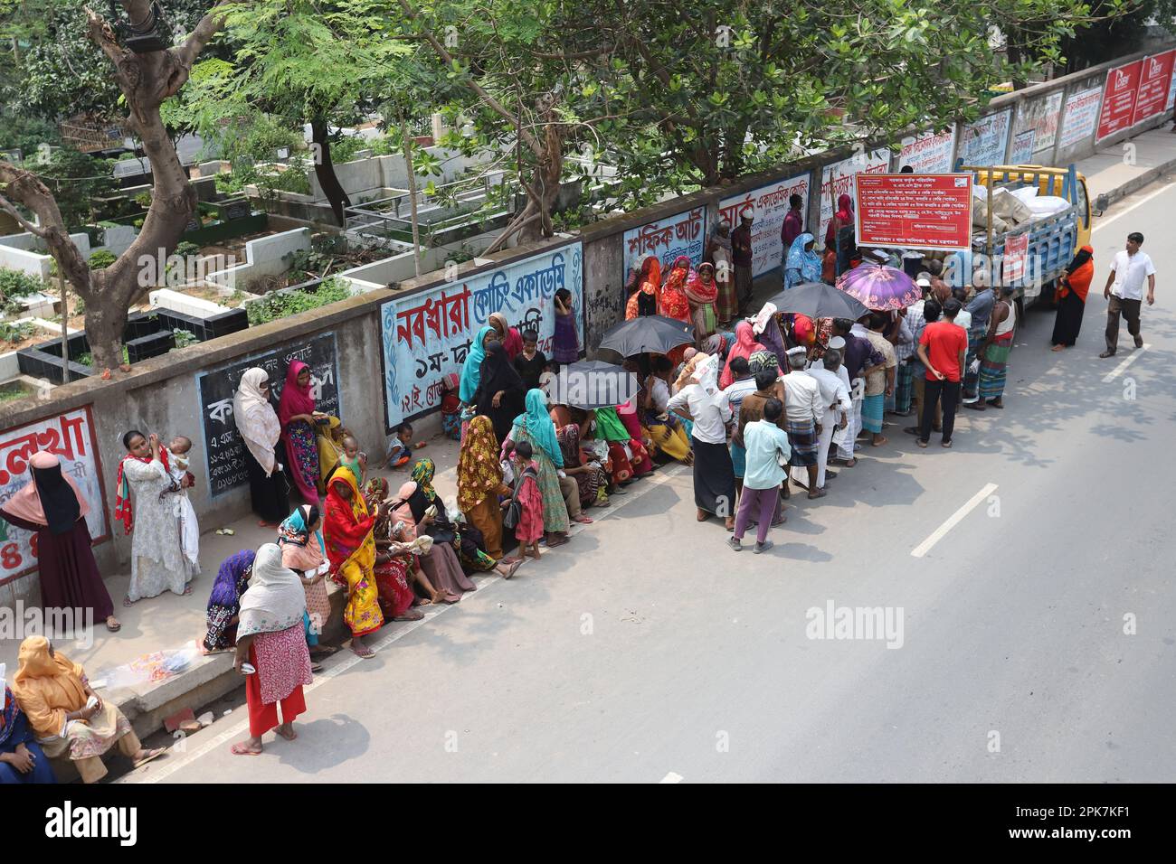 People from low-income groups wait in queues in front of the food ...