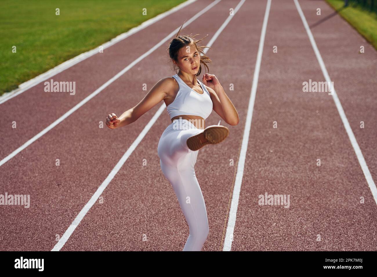 Woman is on the running track exercising outdoors Stock Photo - Alamy