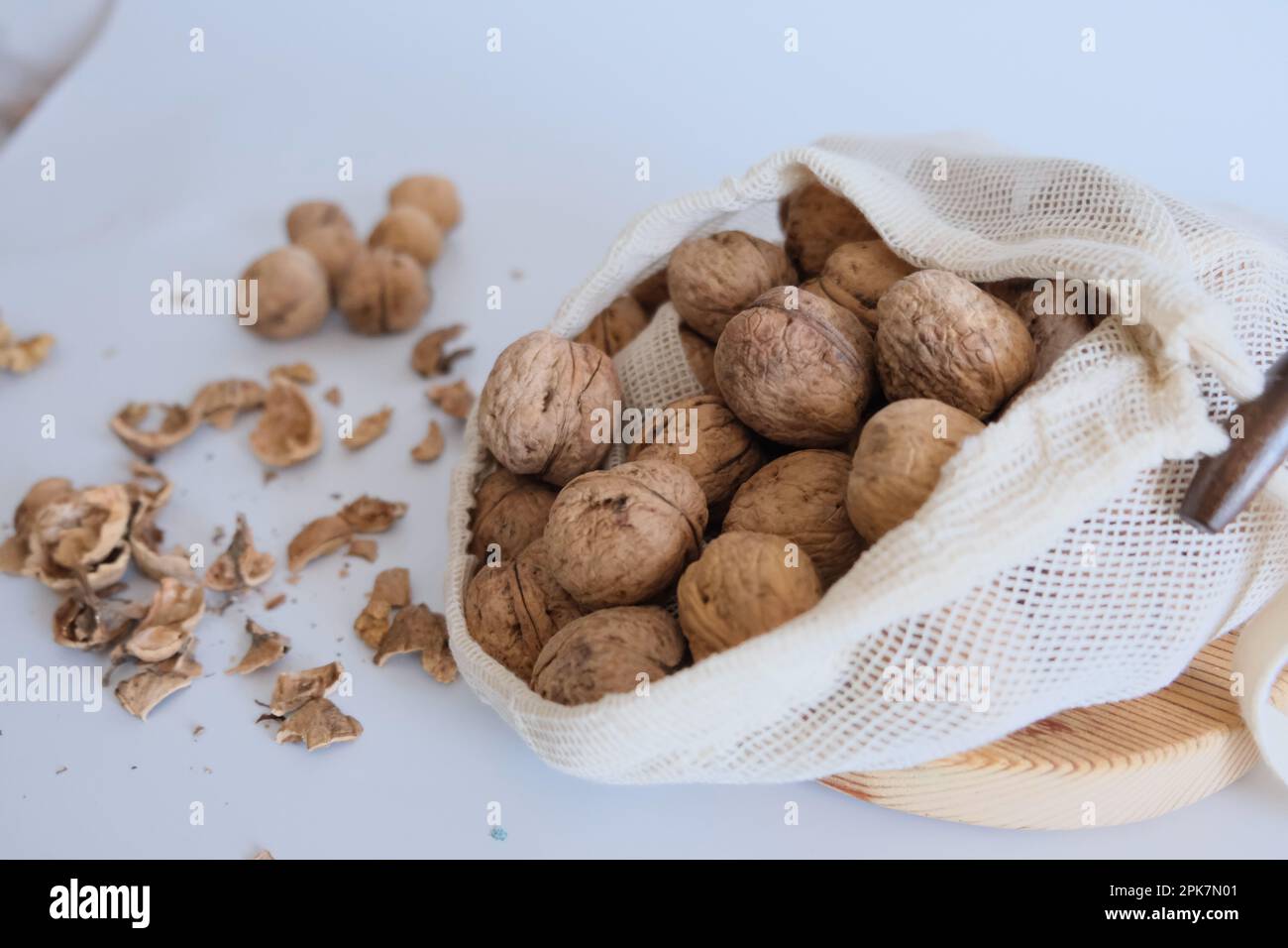 Walnut kernels, walnut shells and a white cloth bag full of whole ...