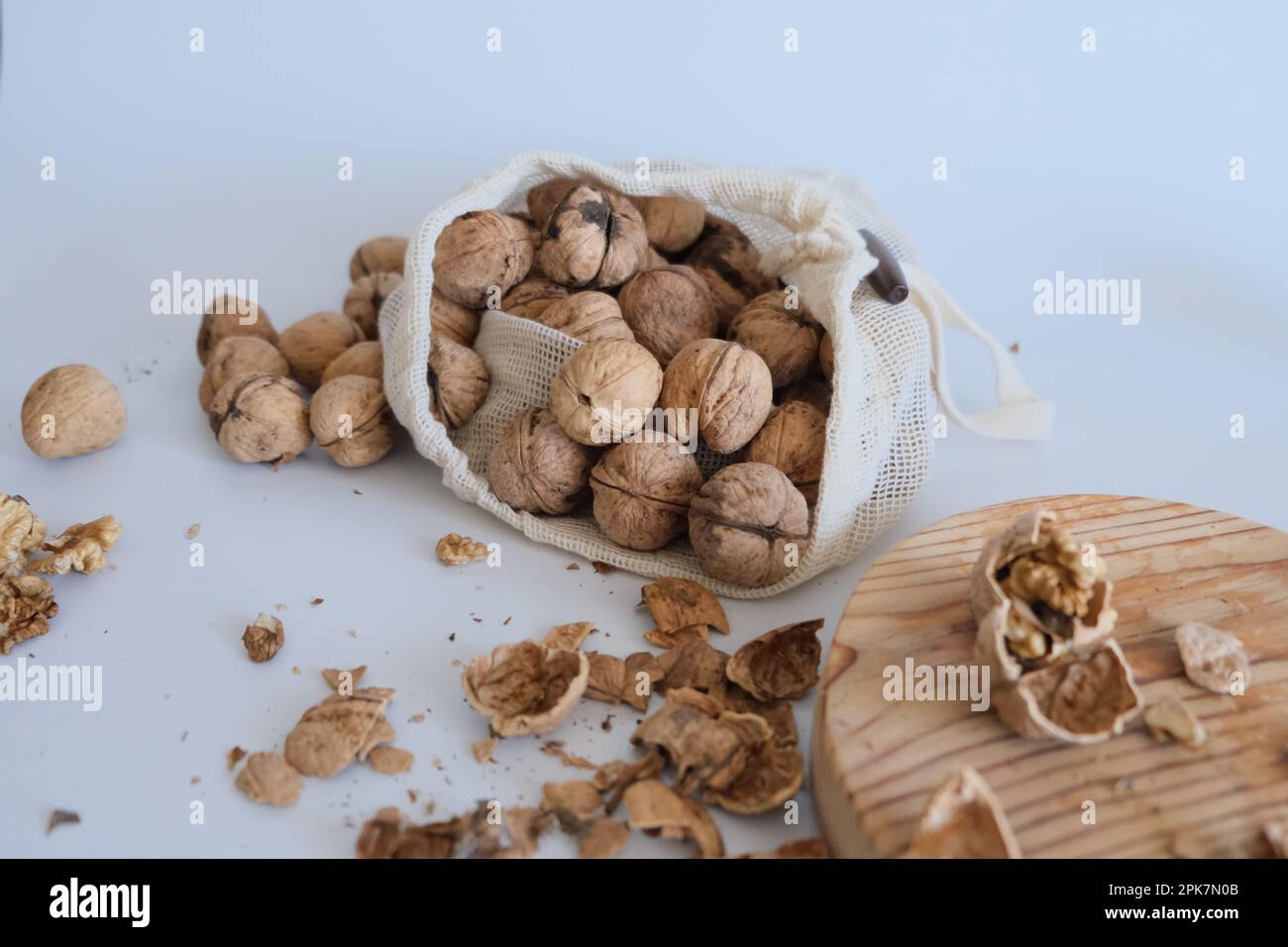 Walnut kernels, walnut shells and a white cloth bag full of whole ...