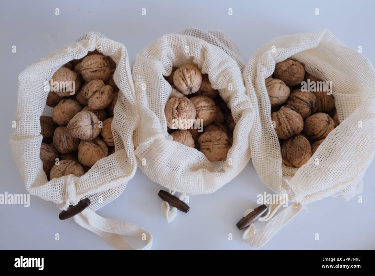 Shelled walnuts, pile of walnuts with shelled in three white cloth bags ...