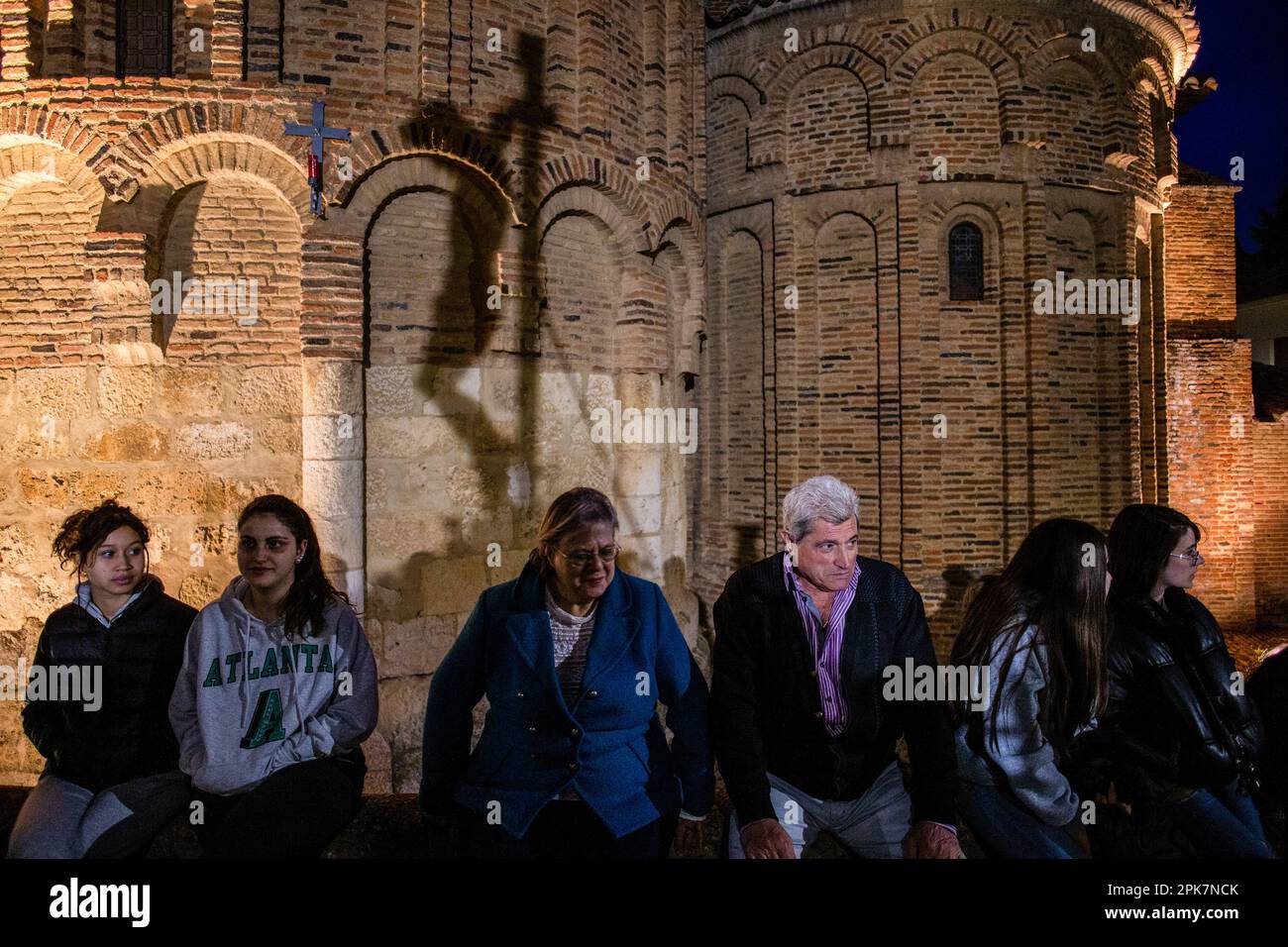 Attendees seated on a bench, observe the processional procession and ...