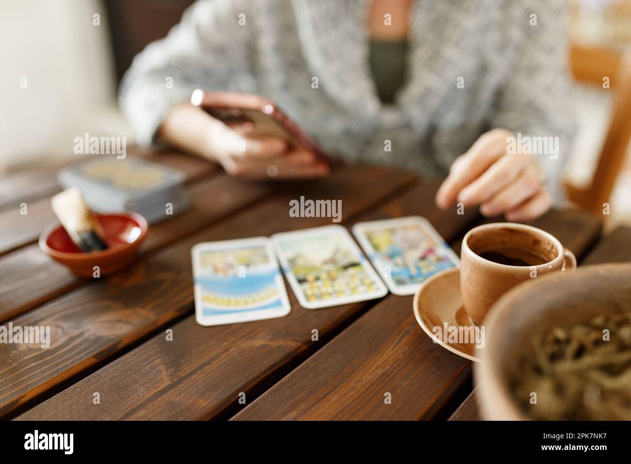 Fortune teller with tarot cards on table near burning candle.Tarot ...