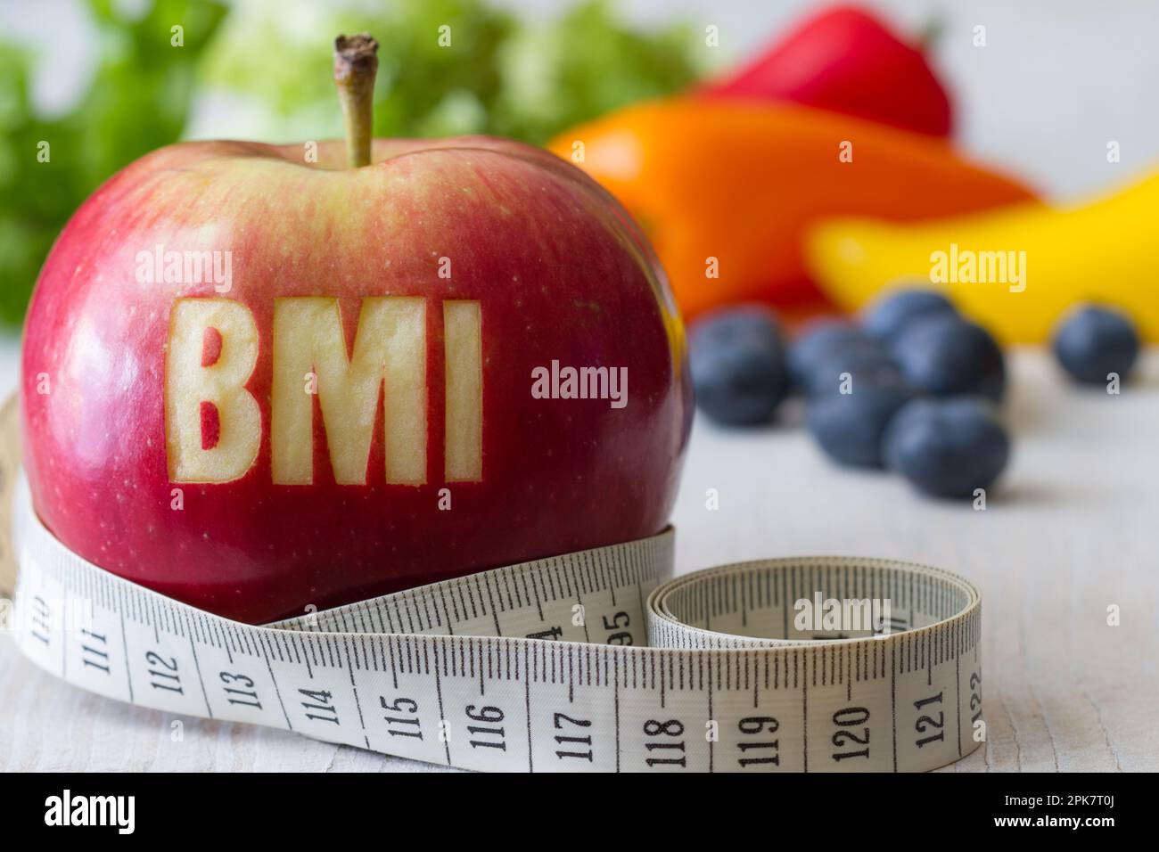 Red apple with text BMI and measuring tape on background of vegetables ...