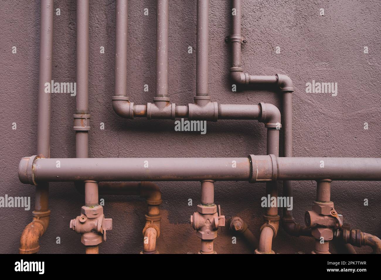 Natural gas utility pipes running along a brown wall, valves and joints Stock Photo - Alamy