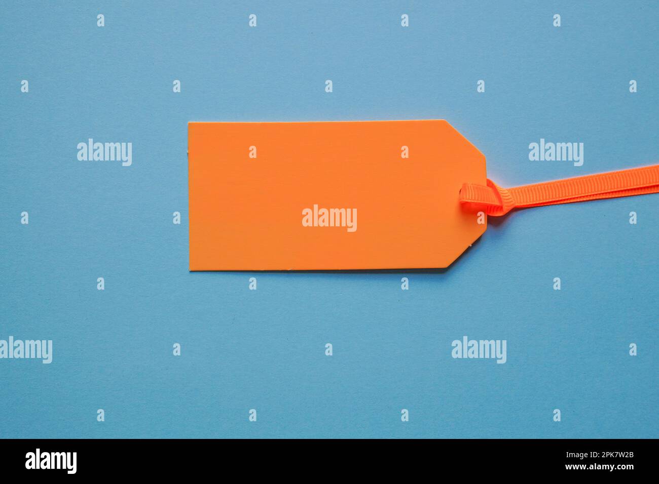orange price tag on the blue background Stock Photo - Alamy