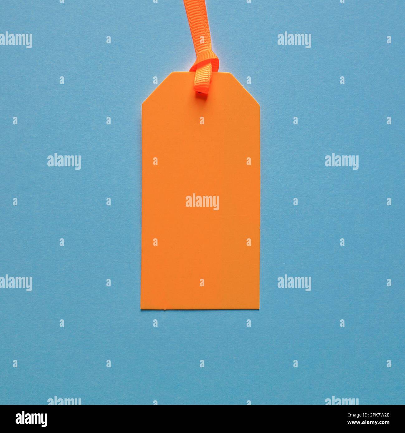 orange price tag on the blue background Stock Photo - Alamy