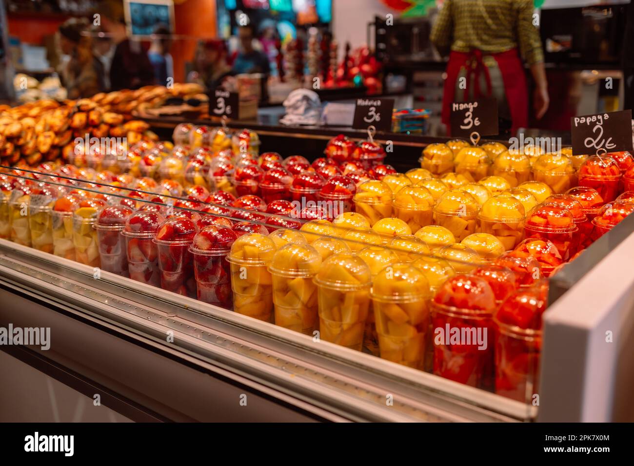 Fruit Salad arranged in plastic cups on a market stall with small fork ...