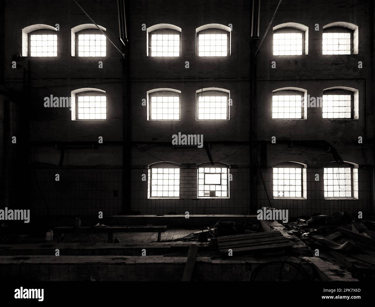 Old interior wall of factory with many windows, black and white shot ...