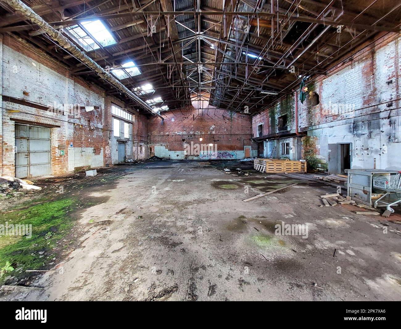 Central perspective of ruined factory hall with debris Stock Photo - Alamy