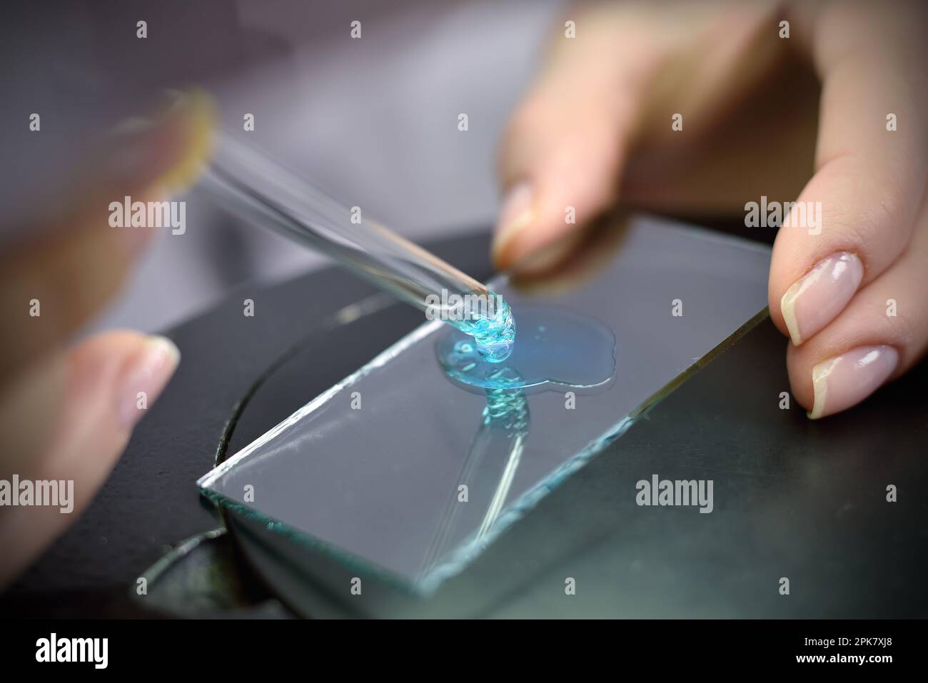 Chemical, biology. Scientist taking a sample of blue liquid with a ...