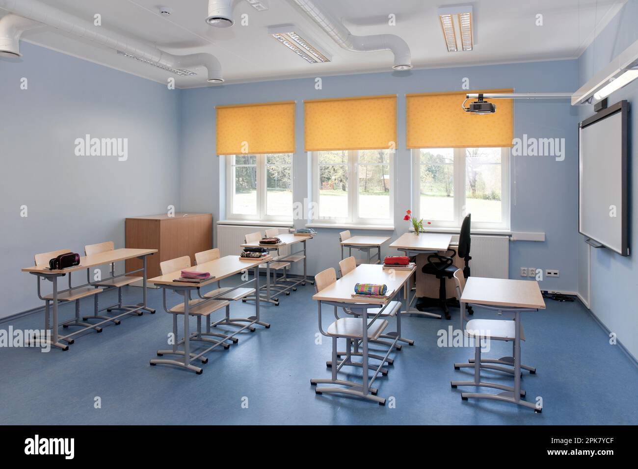 A school classroom with desks and chairs and yellow window blinds Stock ...