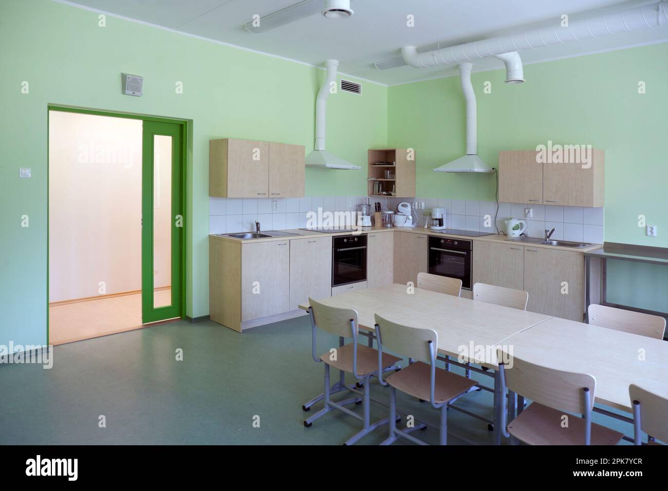 A modern school, a kitchen with fitted cupboards and ovens, a long ...