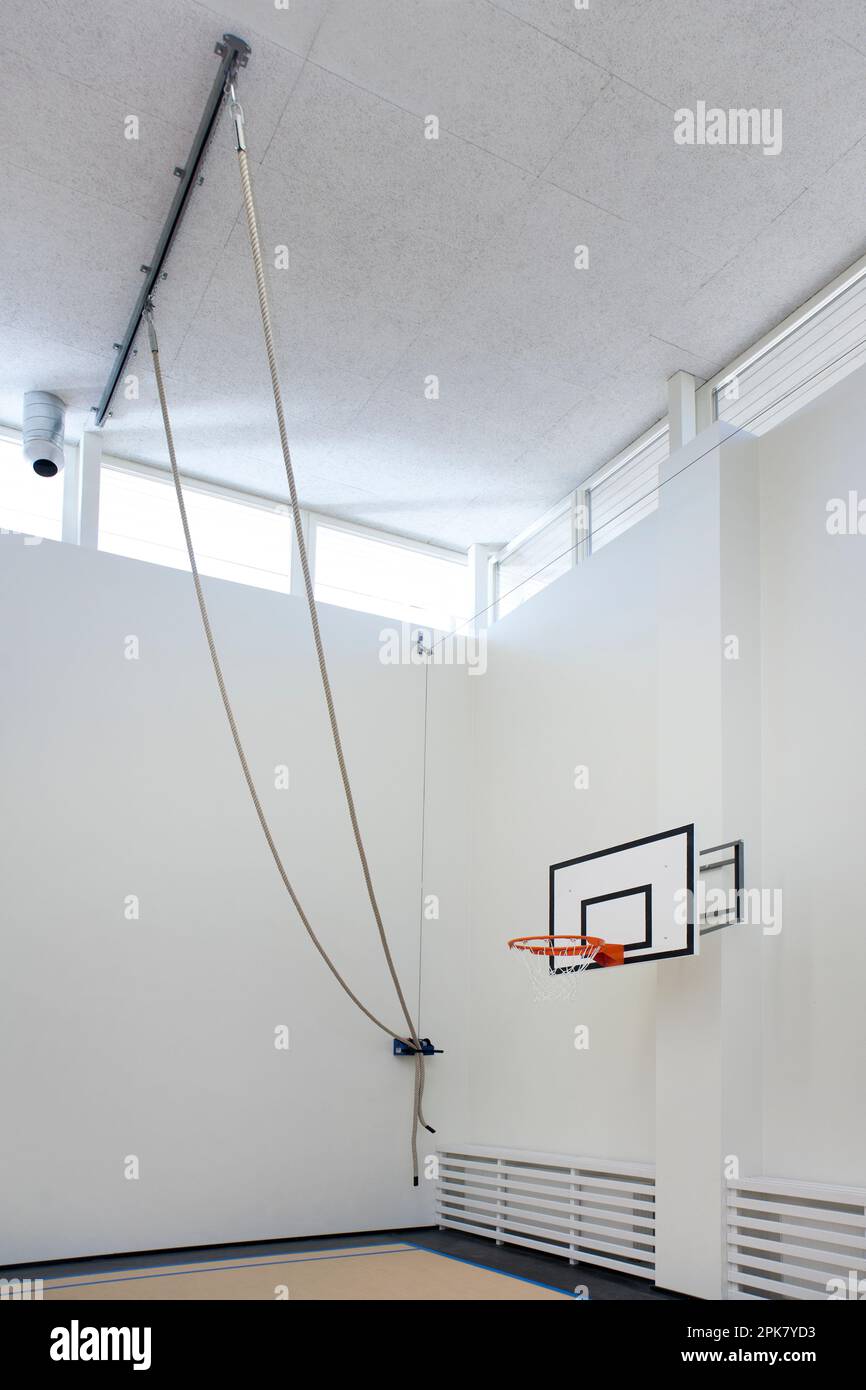 Indoor sports hall in a school, climbing ropes attached to the ceiling ...