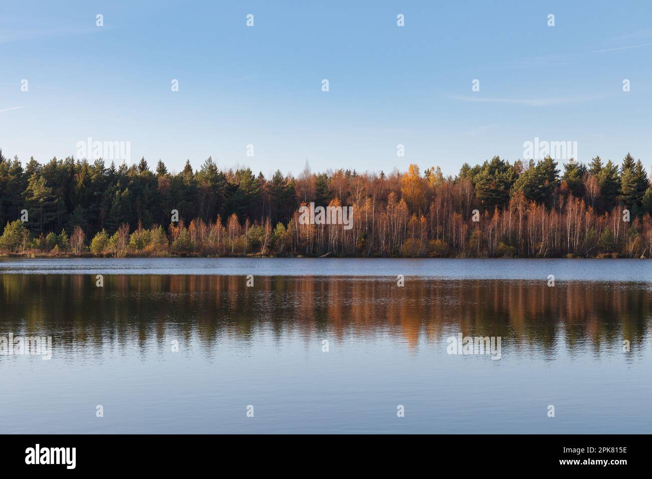 Fall colours of forest reflected in the waters of a lake Stock Photo ...