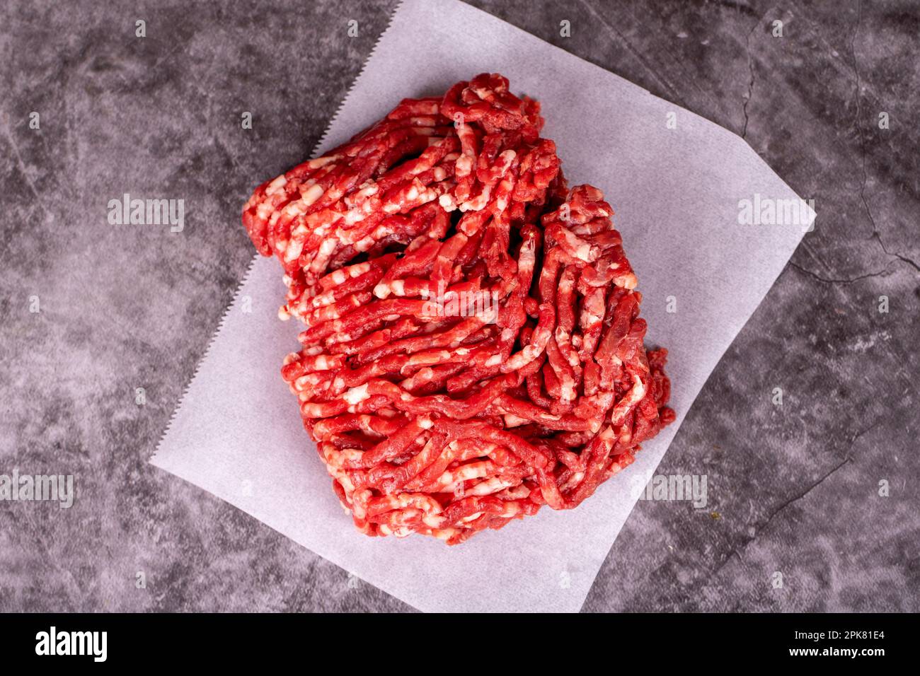 Minced meat on butcher paper. Fresh ground beef on wood background. Top ...