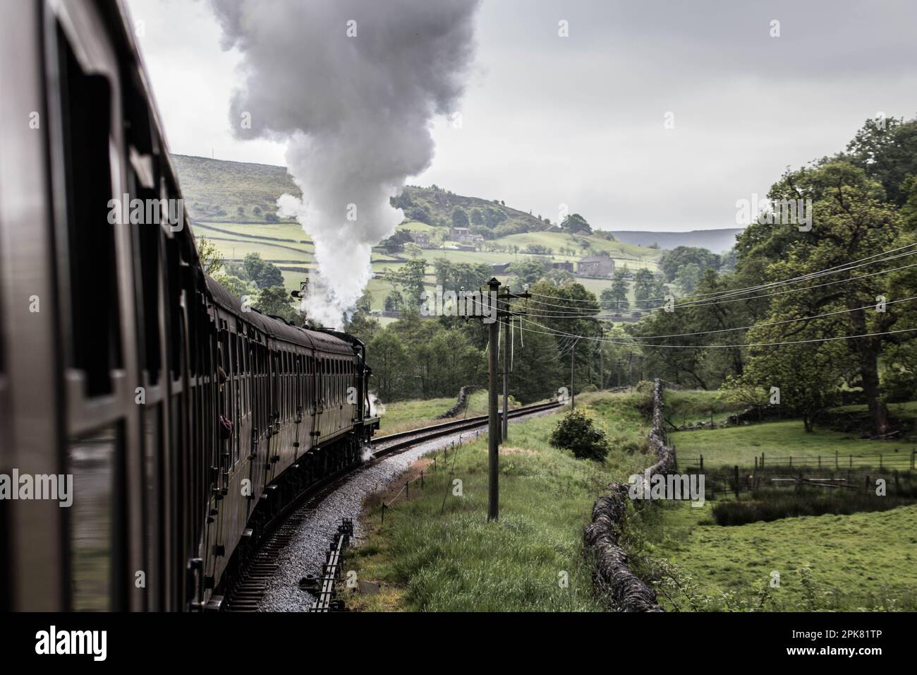 A classic locomotive engine traveling along a railway track, with ...
