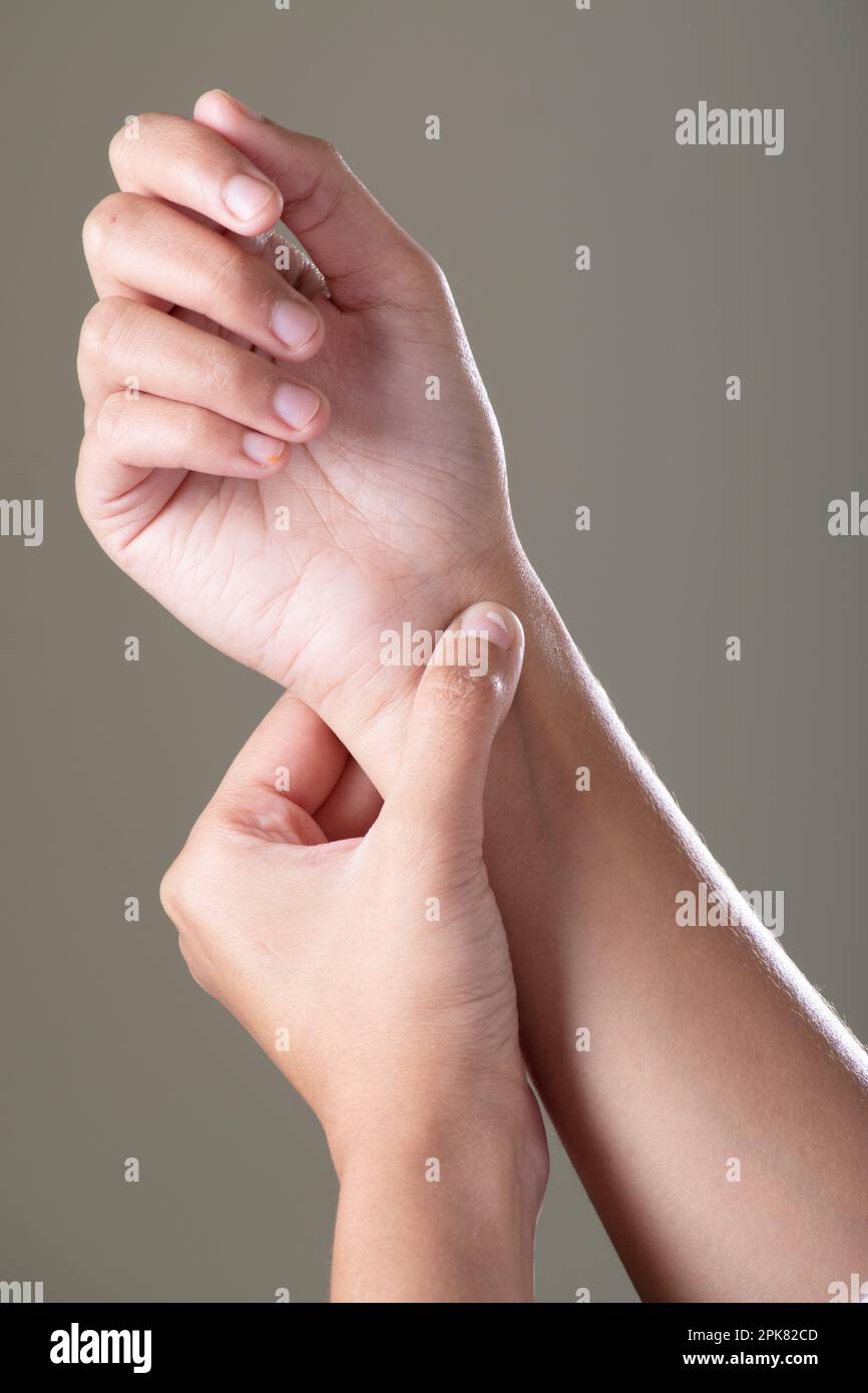 Female hand self checking pulse rate on grey background Stock Photo - Alamy