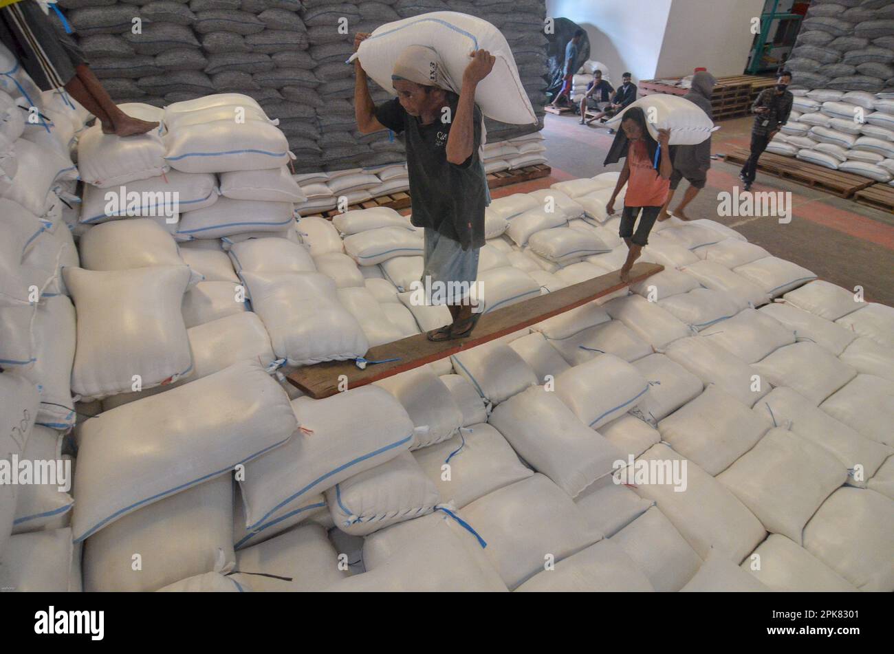Hip laborers carrying bags of rice into a warehouse owned by Bulog in ...