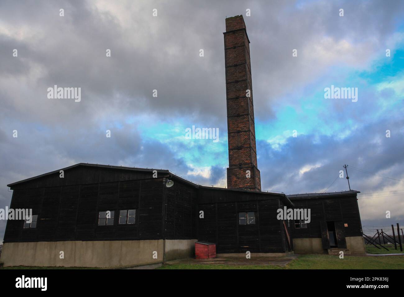 A building with a chimney against the cloudy sky. Auschwitz ...