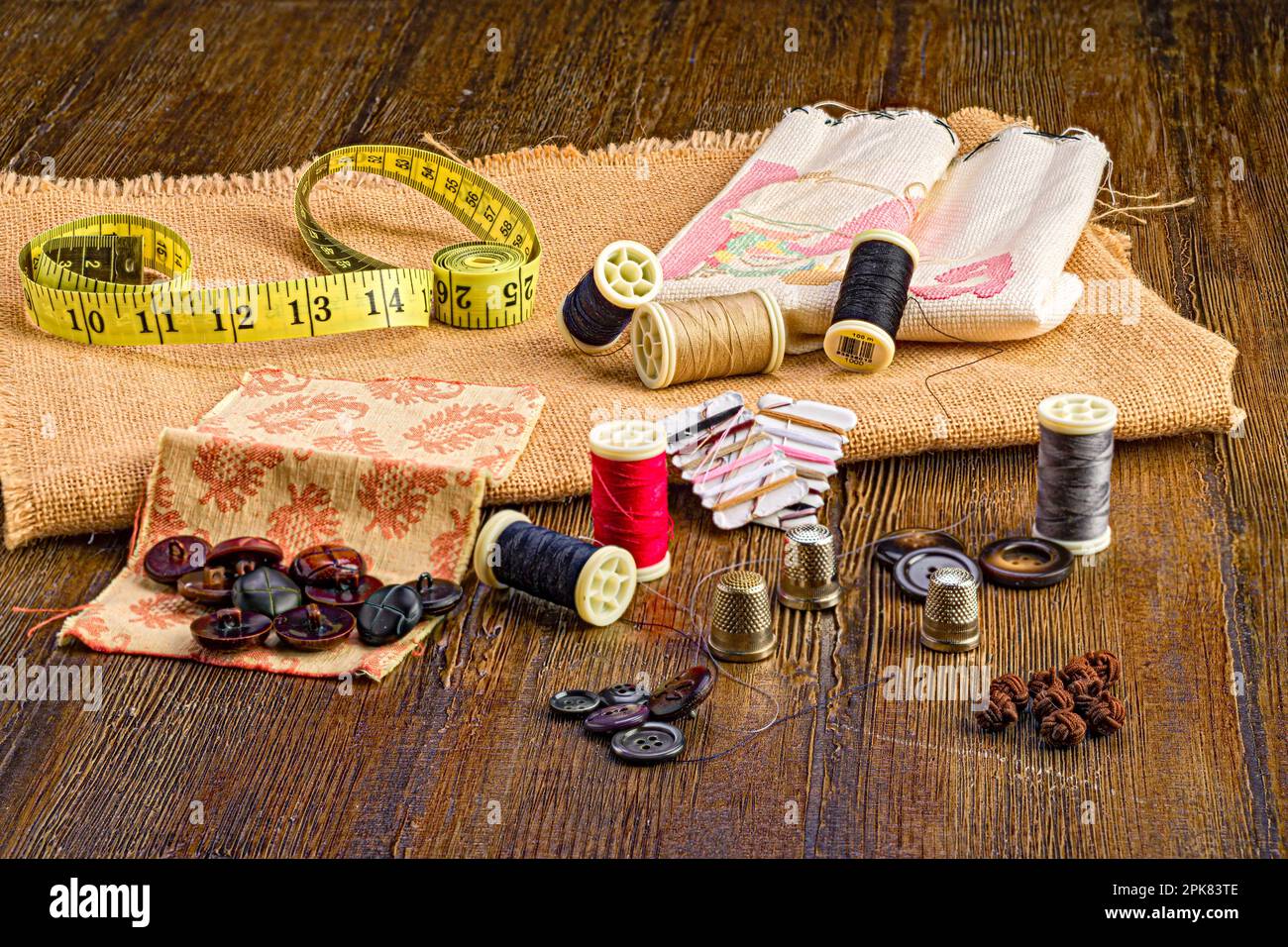 A still life composition featuring various sewing items arranged on a ...