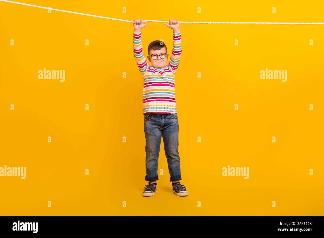 Full length photo of sporty kid hanging on string playing game outdoors ...