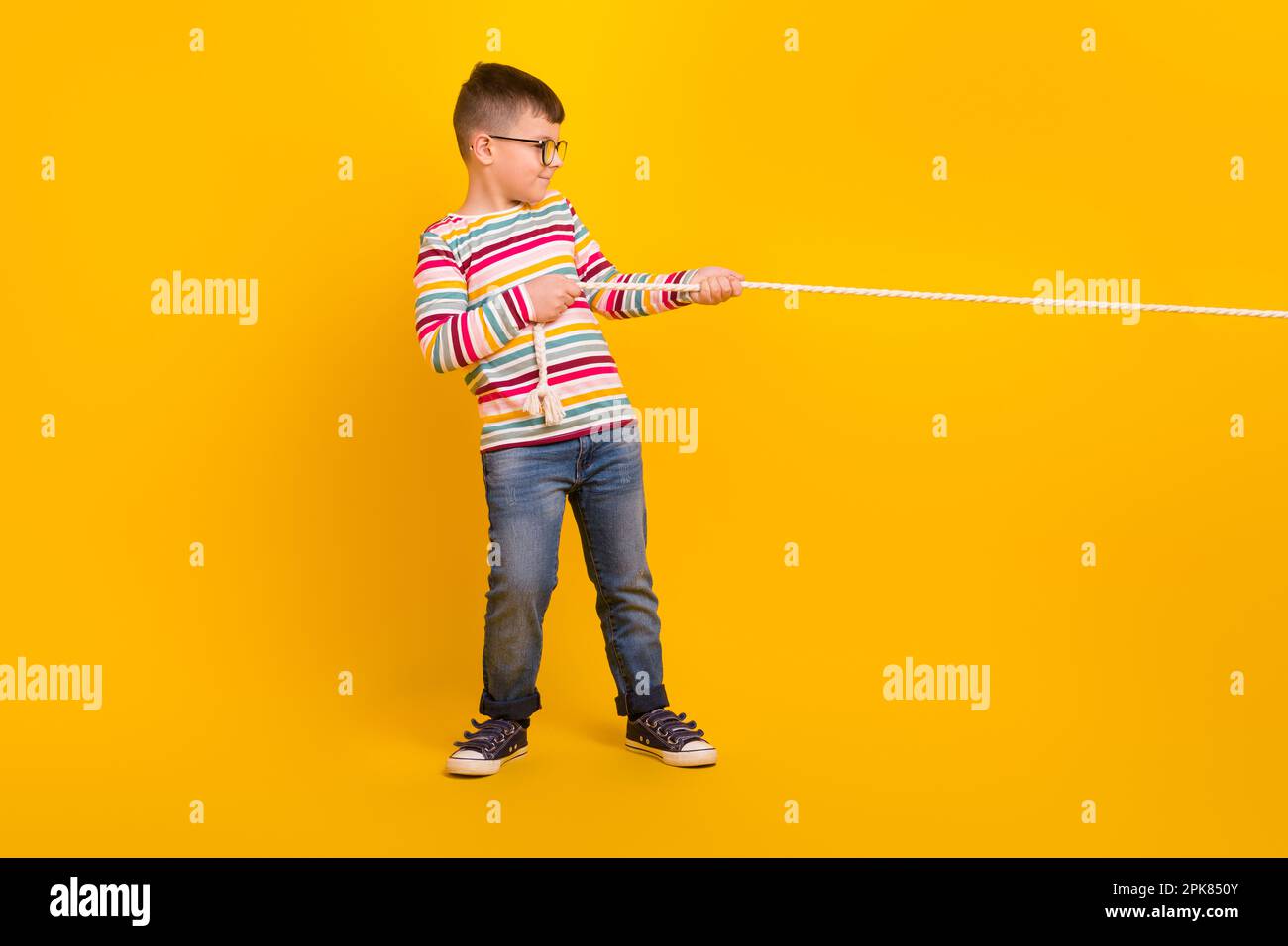Full profile side photo of sweet kid boy playing outdoors pull string ...
