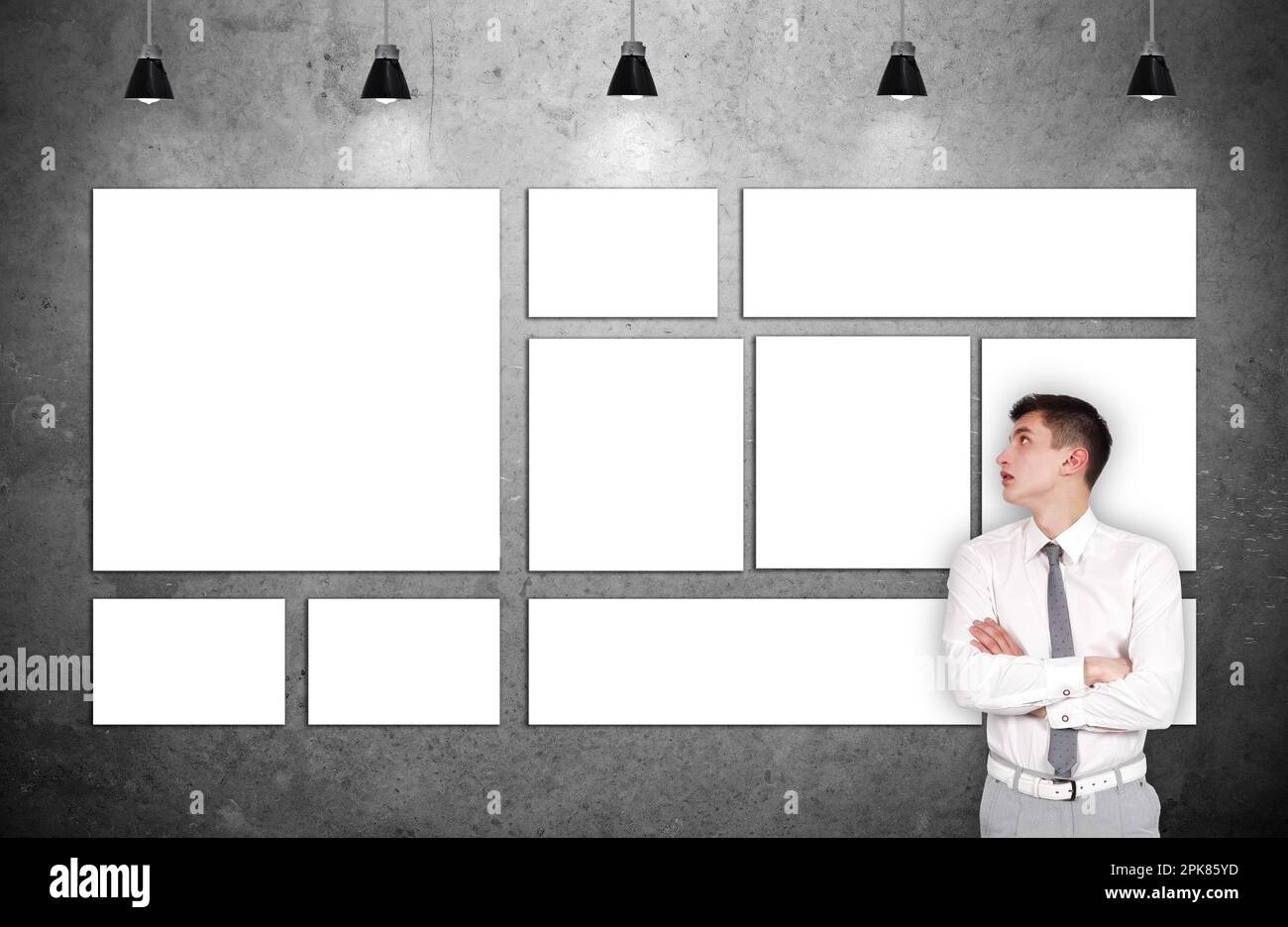 young businessman thinking standing in gallery with many blank frame ...