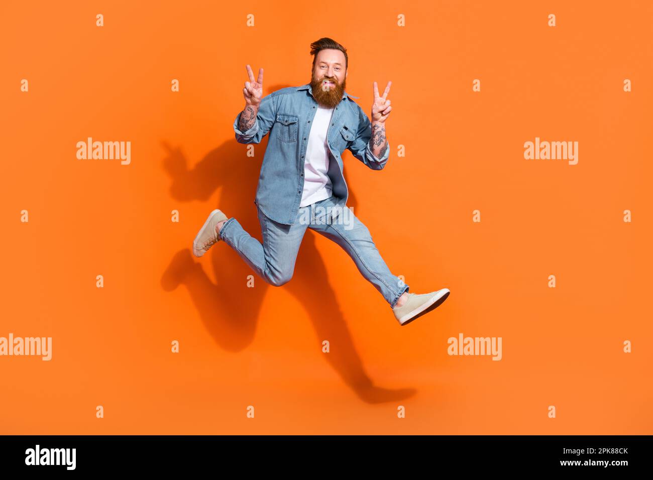 Full body photo of energetic man jumping demonstrate v-sign isolated on ...