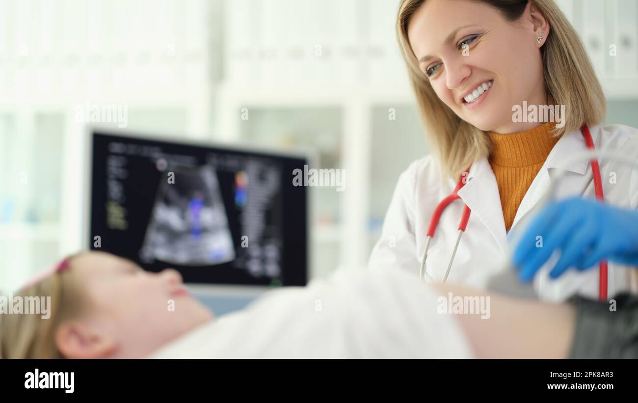 Doctor pediatrician conducting abdominal ultrasound examination of ...