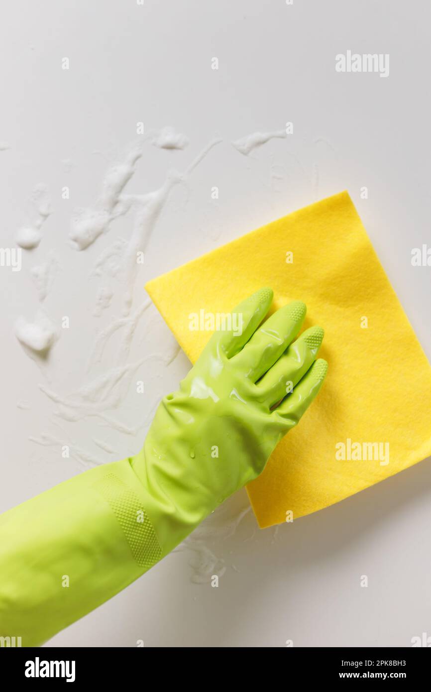 Hand in Green Glove with Microfiber Rag Cleaning White Surface with ...